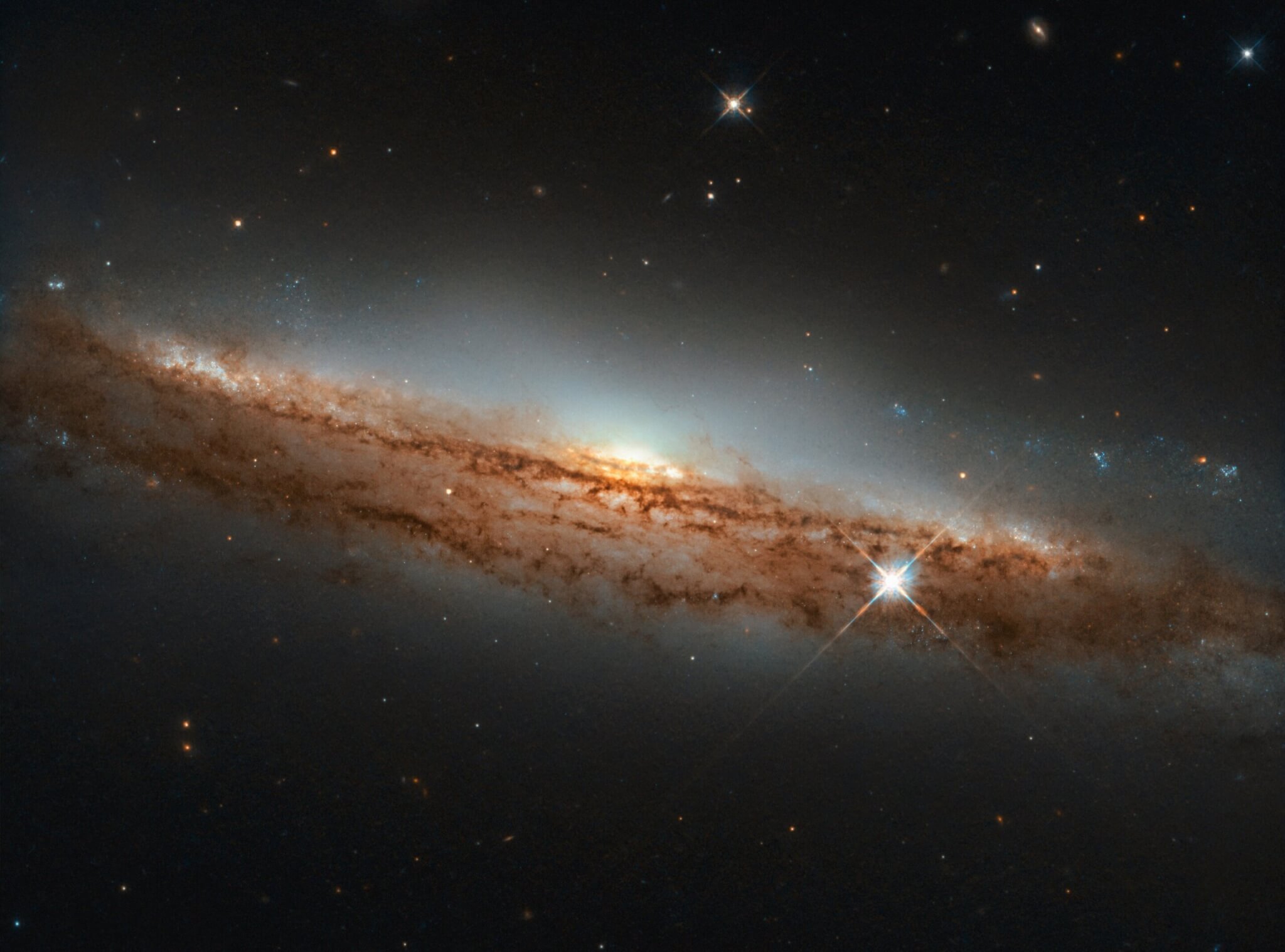 Teleskop Hubble'a zobrazował położoną bokiem galaktykę spiralną w ...